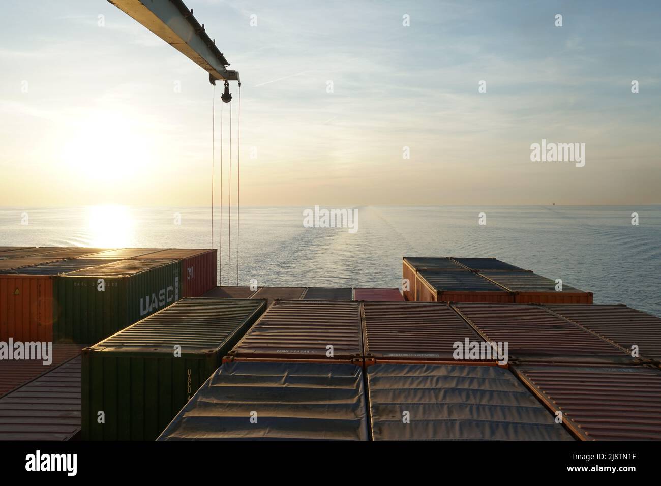 Sunset observed behind the container vessel with crane from ...