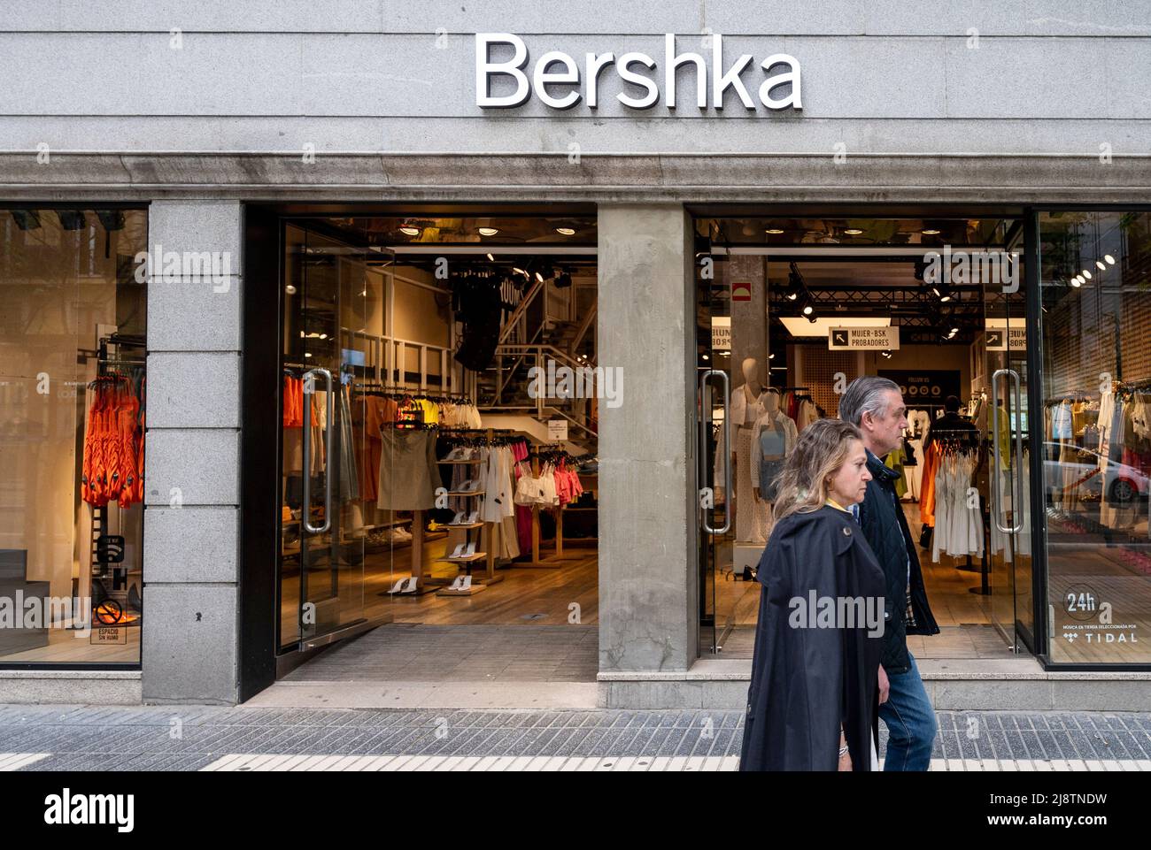 Pedestrians walk past the Spanish fashion brand owned by Inditex ...