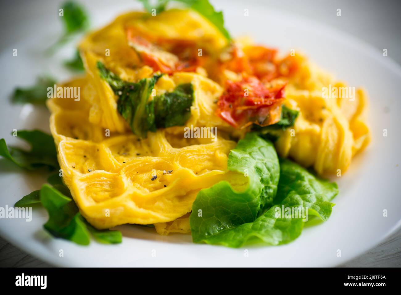 Egg omelet stuffed with tomato and greens fried in the form of waffles ...