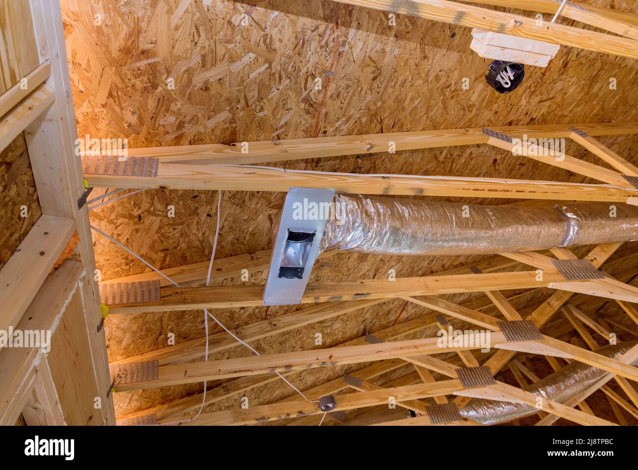 Ventilation pipes in silver insulation material hanging from the ...