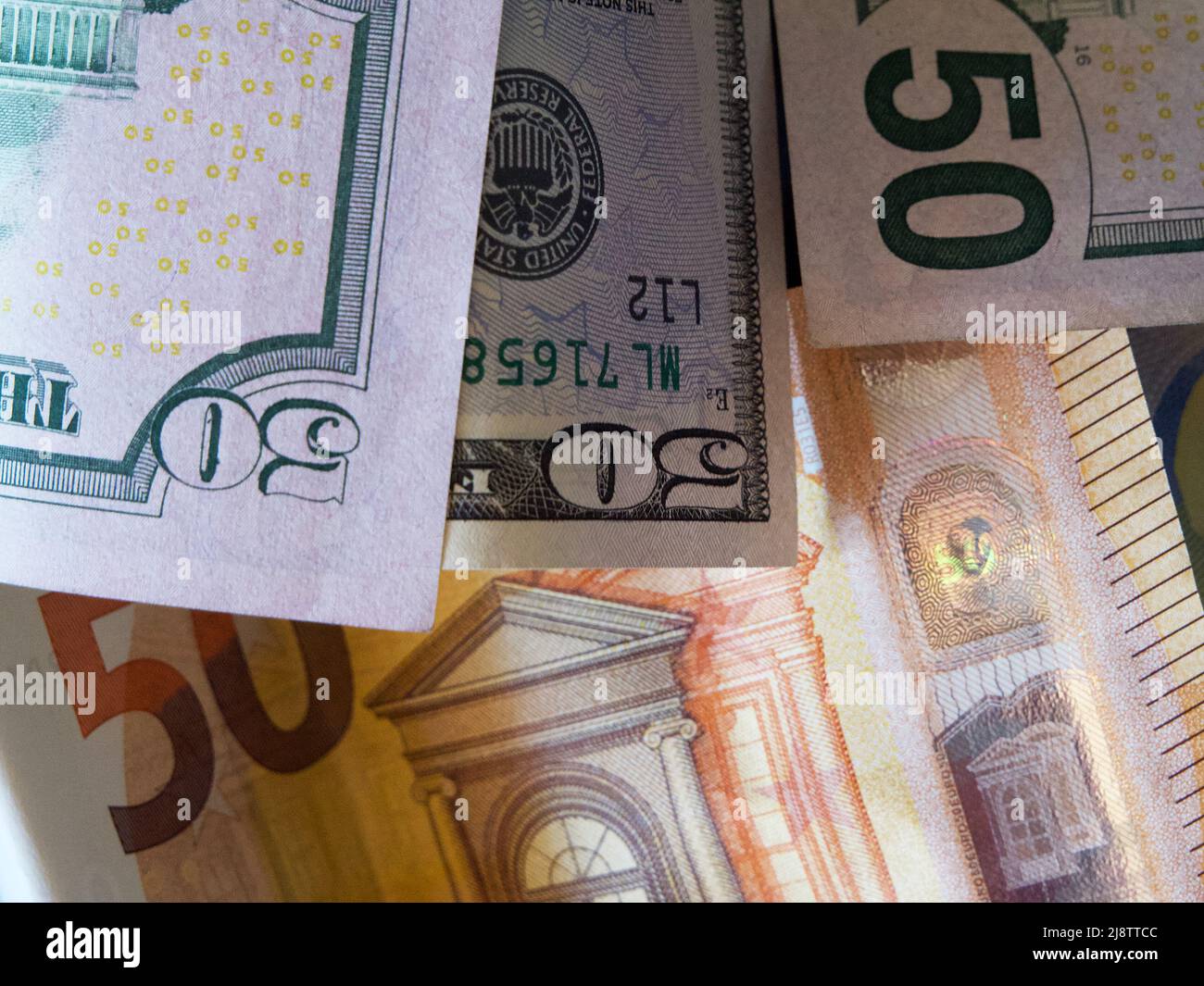 Paper banknotes in denominations of 50 dollars and 50 euros, a close-up ...