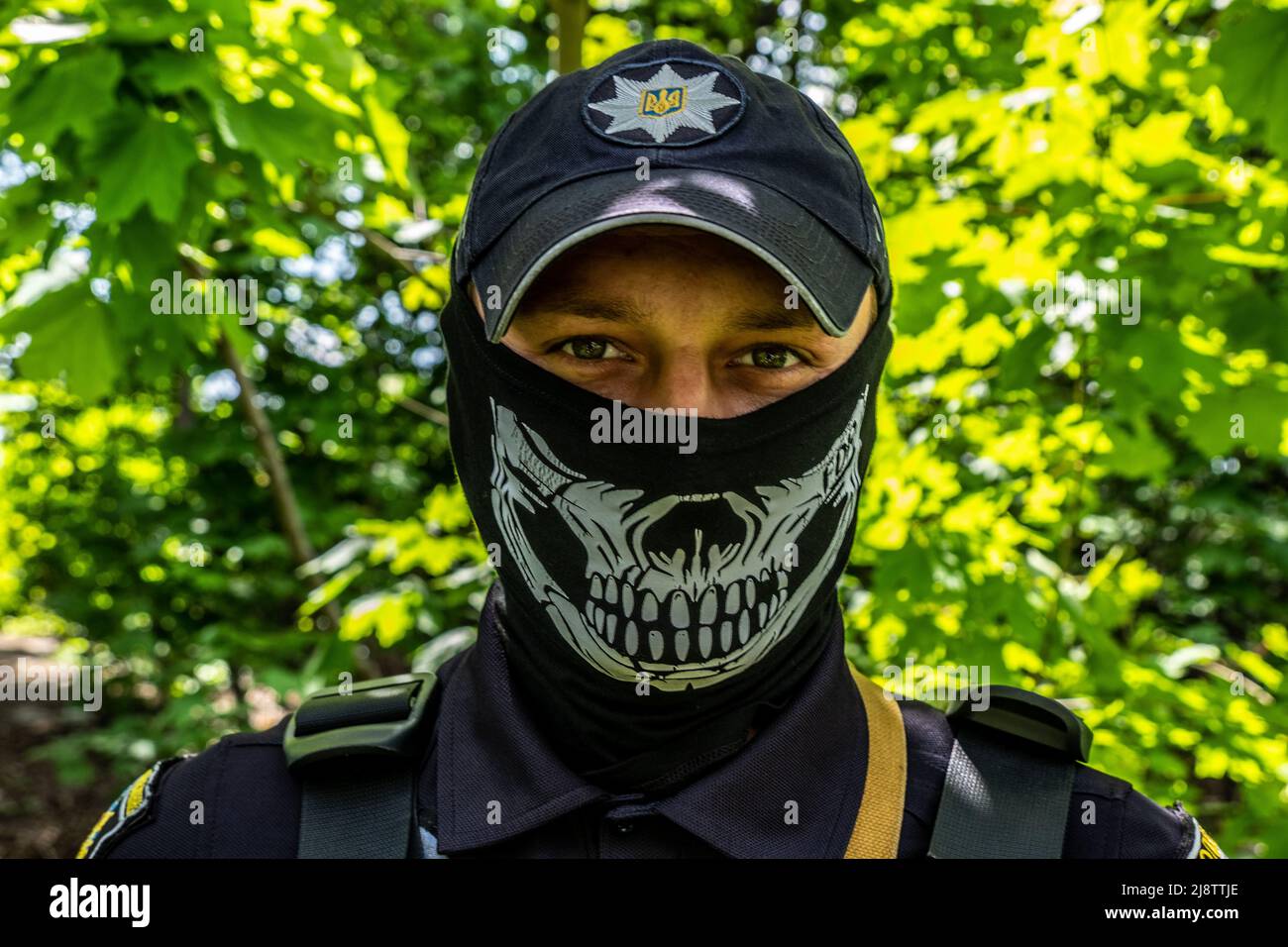A policeman wearing a skull face mask and a bullet proof vest poses at ...