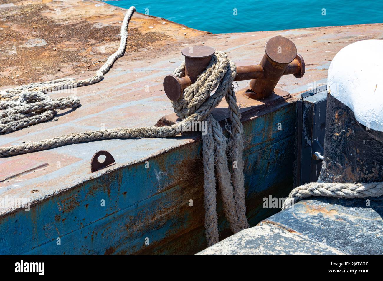 Photo of a mooring post with a rope tied around it. Marine knot ...