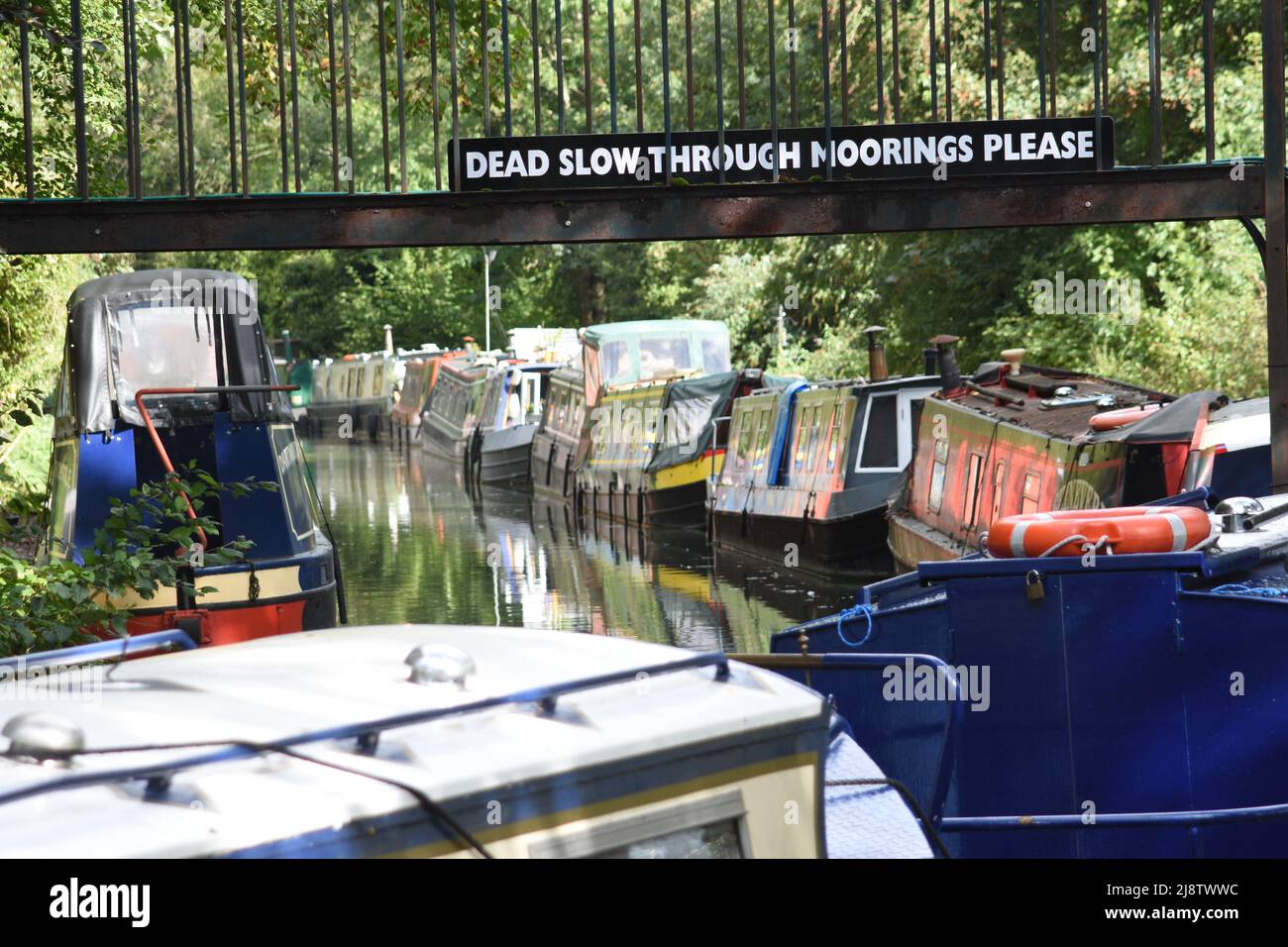 Dead slow bridge sign with canal boats moored at Bath & Dundas Canal in ...