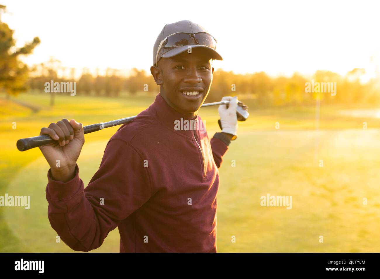Portrait of smiling african american young man wearing cap with golf ...