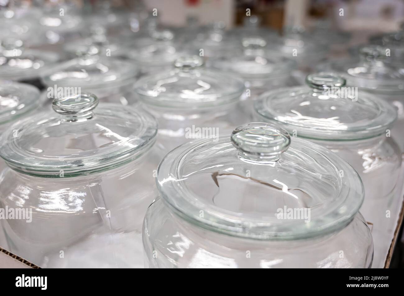 A group of empty cans with a lid. Rows of glass containers in a store ...