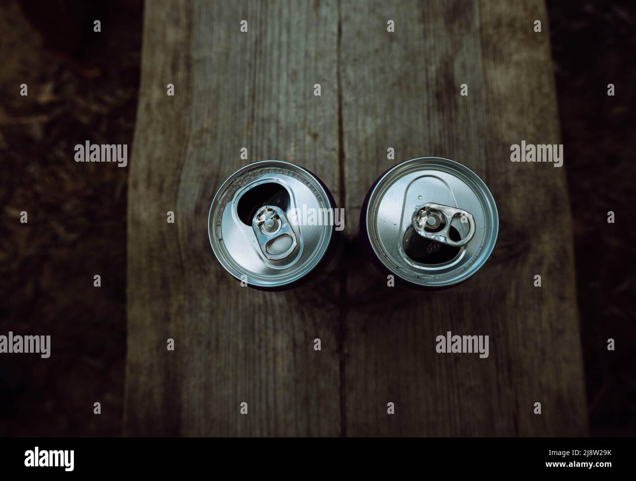 Two beer cans side by side. on a wooden board Stock Photo - Alamy