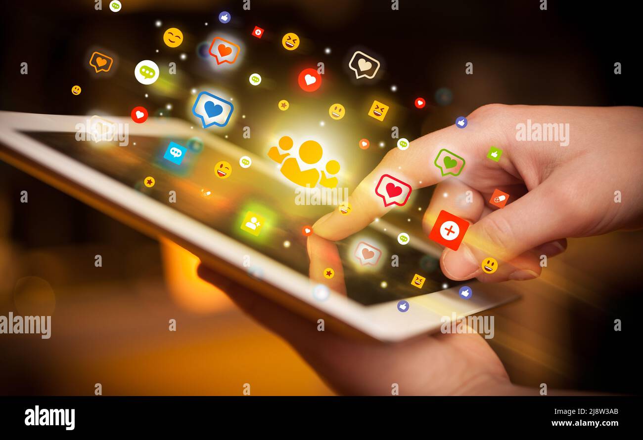 Close-up of a hand using tablet with social media icons Stock Photo - Alamy
