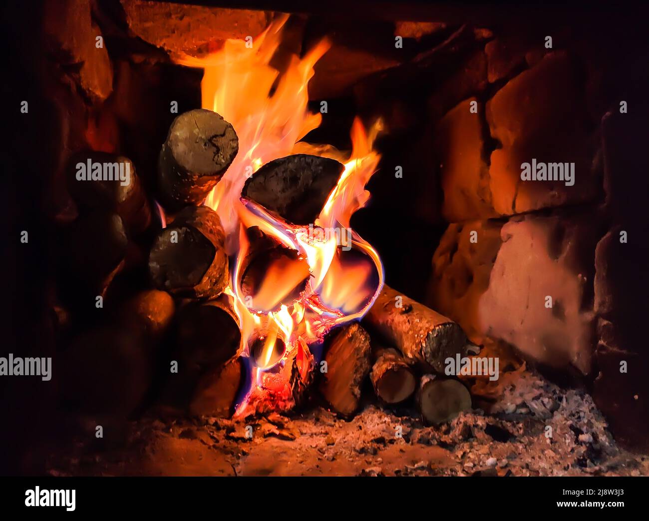 Burning firewood in fireplace in country cottage Stock Photo - Alamy