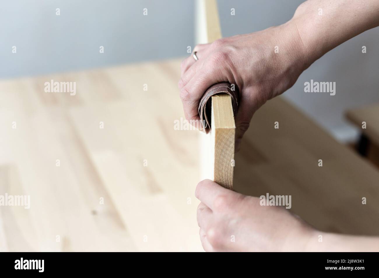 Sanding boards by hand. Sanding with abrasive paper Stock Photo - Alamy