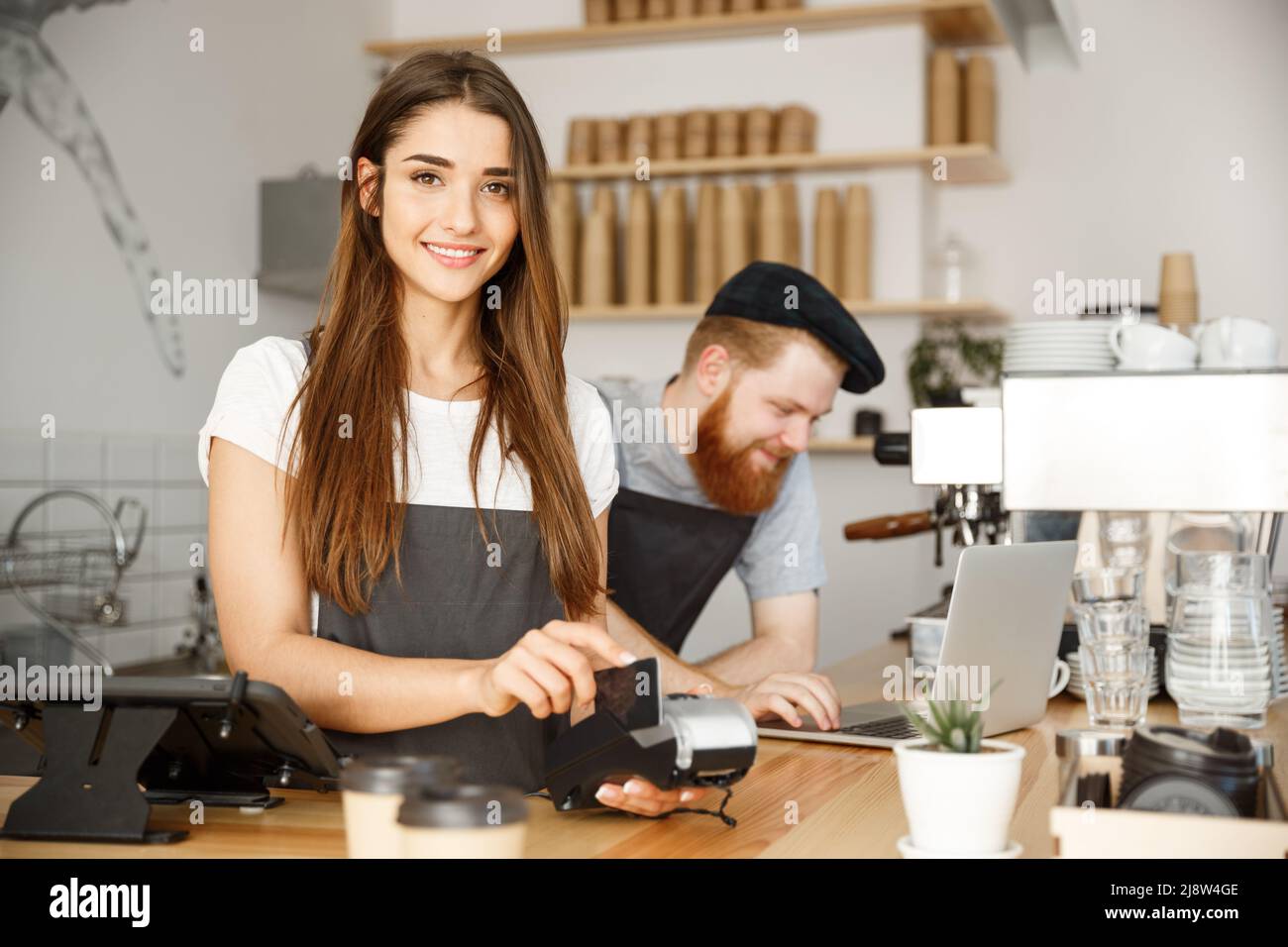 Coffee Business Concept - Beautiful female barista giving payment ...