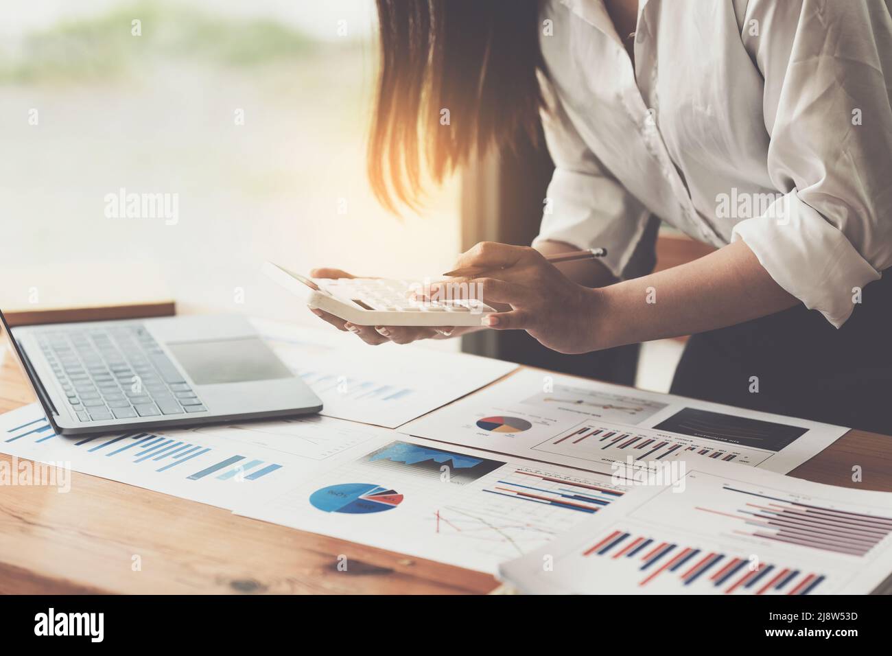 Close up Business woman hand using calculator to calculate the company's financial results and ...