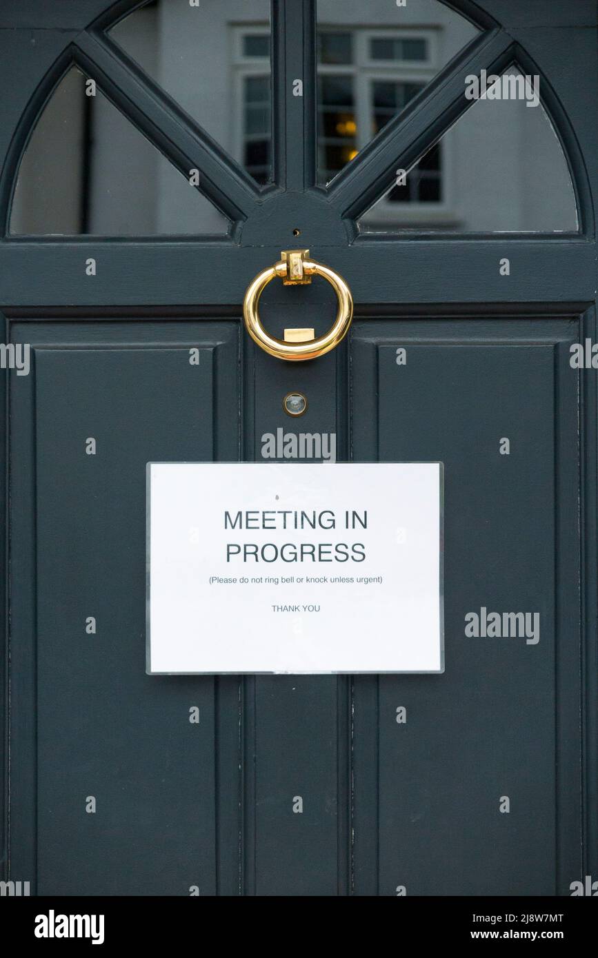 Meeting in progress sign attached to a domestic house front door ...