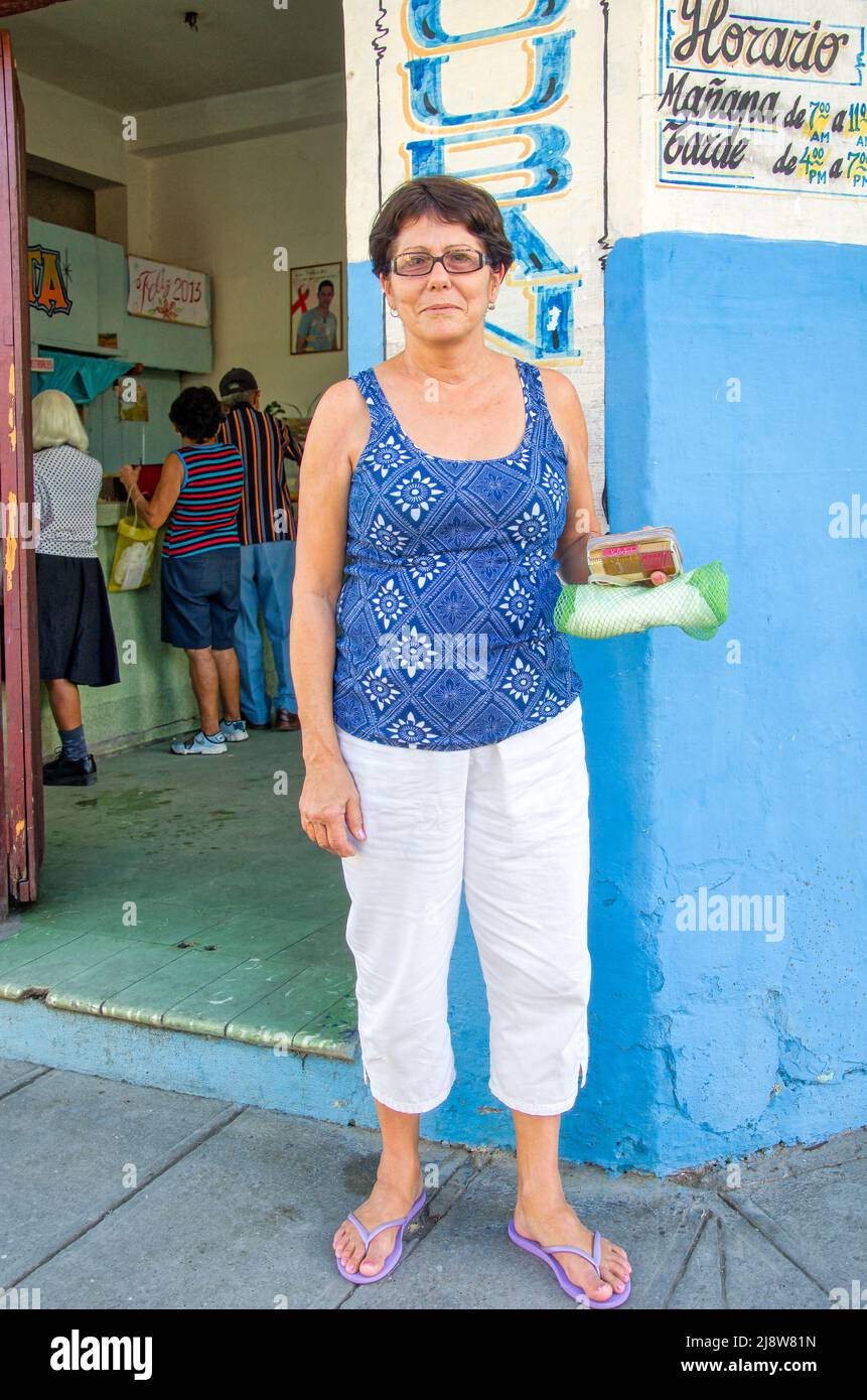 Full length portrait of a real Cuban woman outside a ration book ...