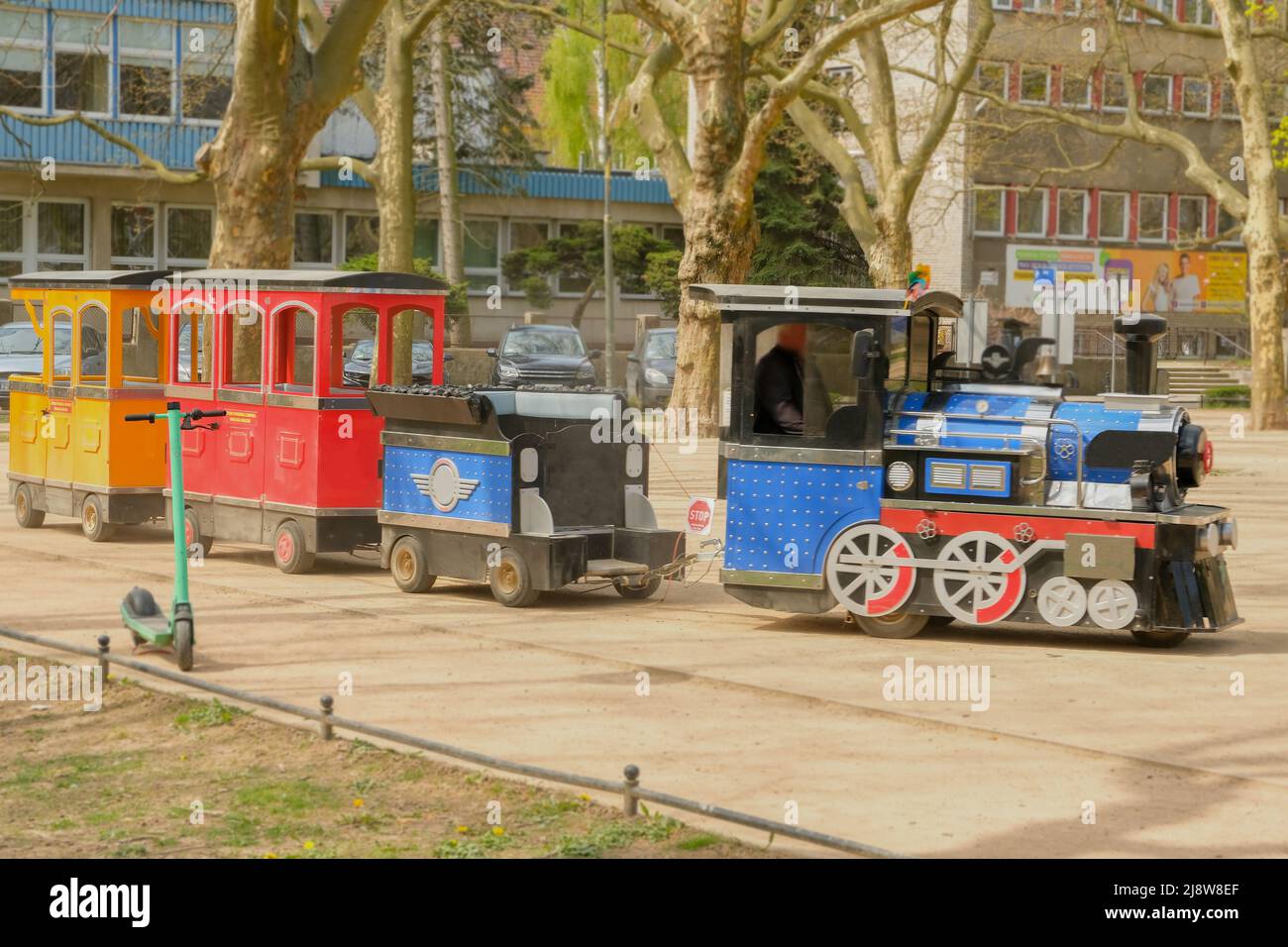 Cute boy rides the railroad on a children's colored locomotive ...