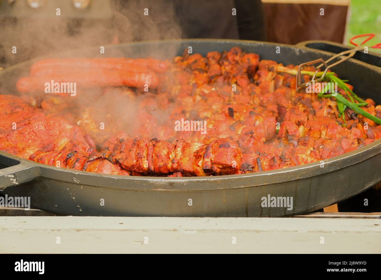 Fry the meat in a large cast-iron cauldron Stock Photo - Alamy