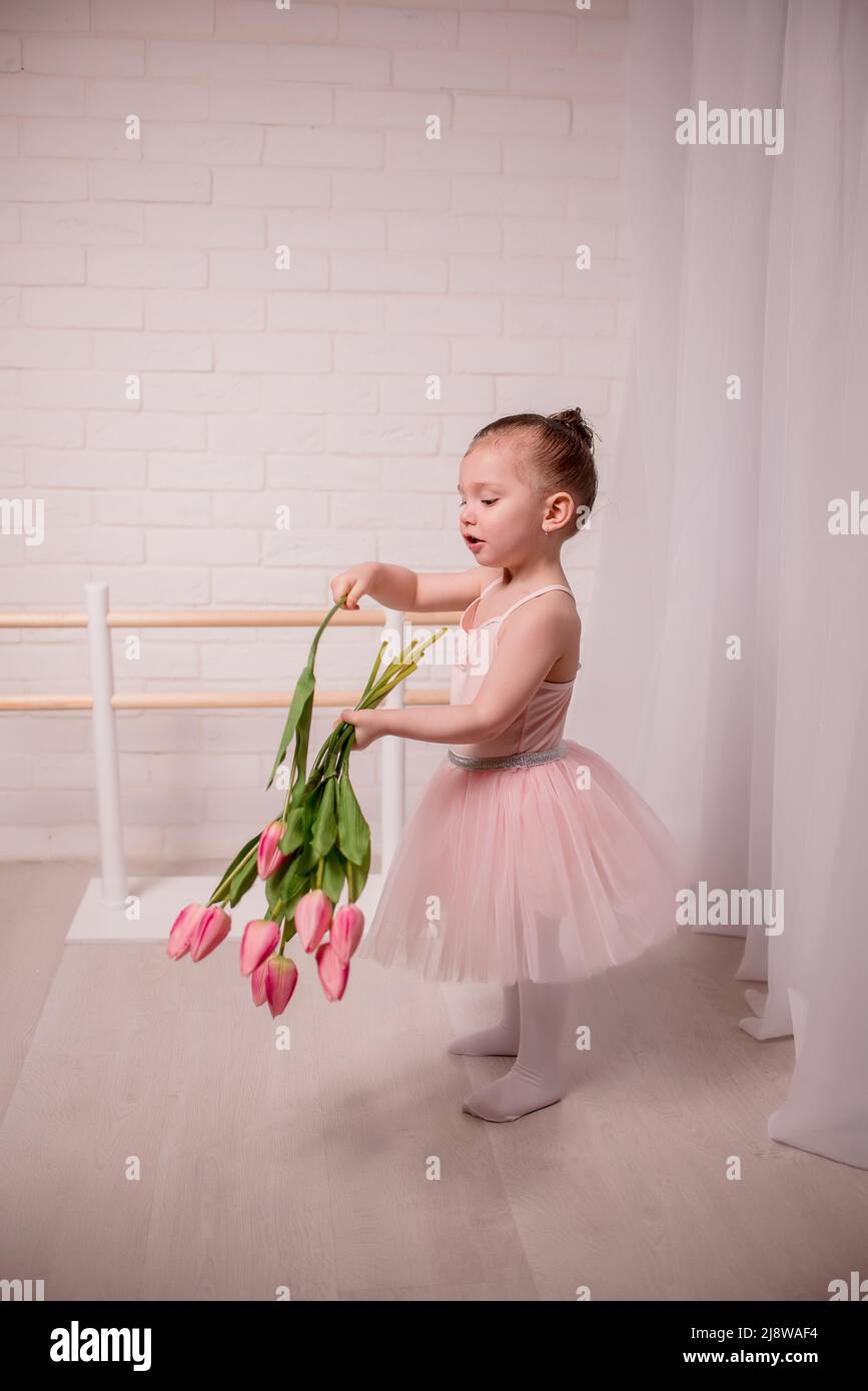 Cute little girl ballerina and her teacher doing exercises in ballet ...