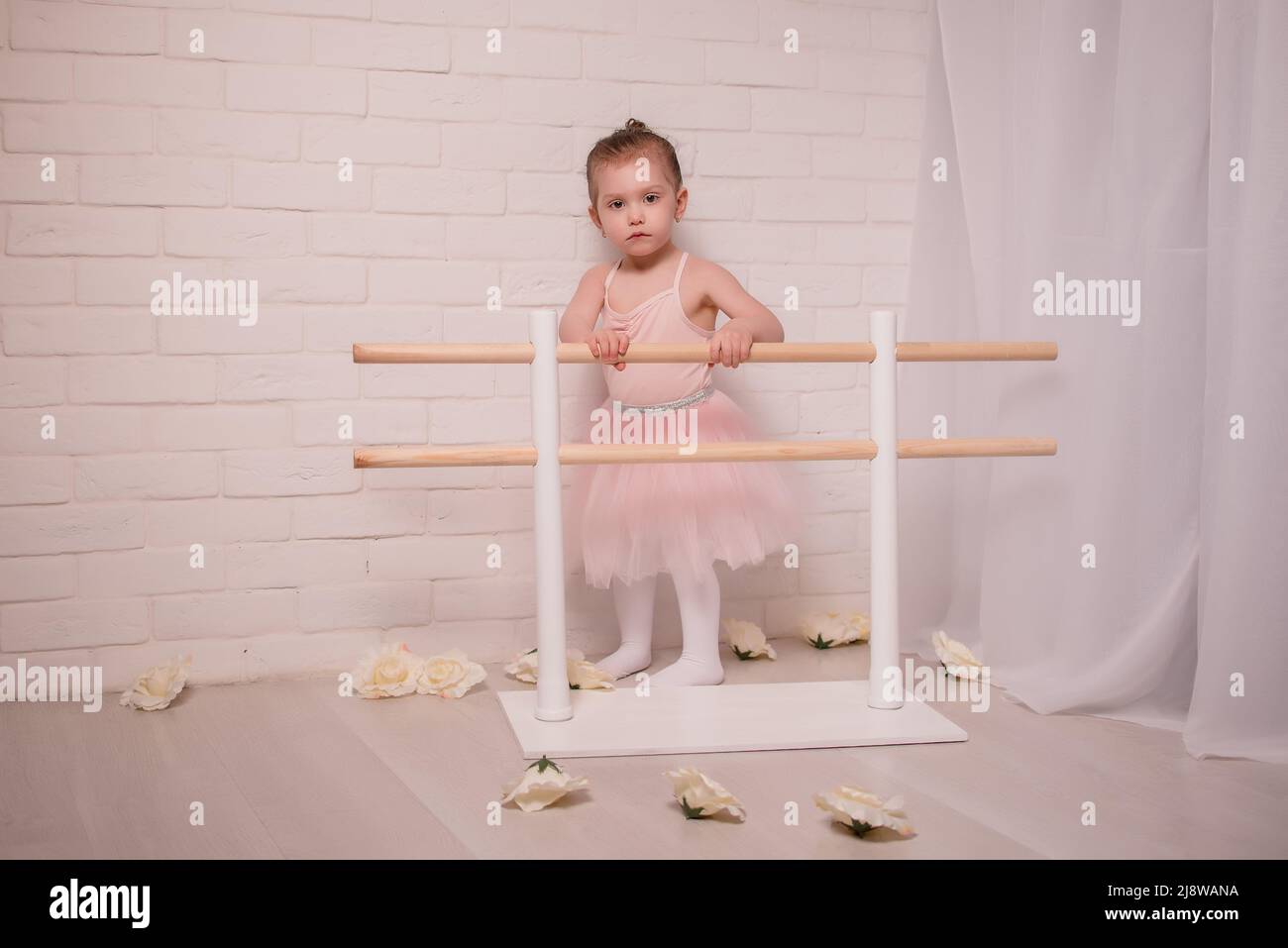 Cute little girl ballerina and her teacher doing exercises in ballet ...