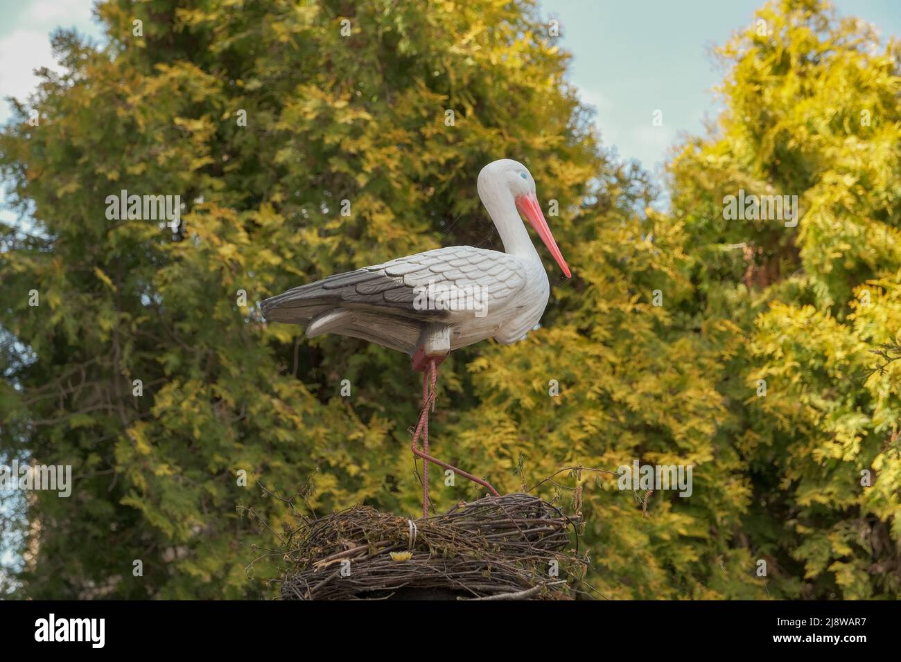 Artificial stork in the garden. Statues of stork. Plastic bird stork in ...