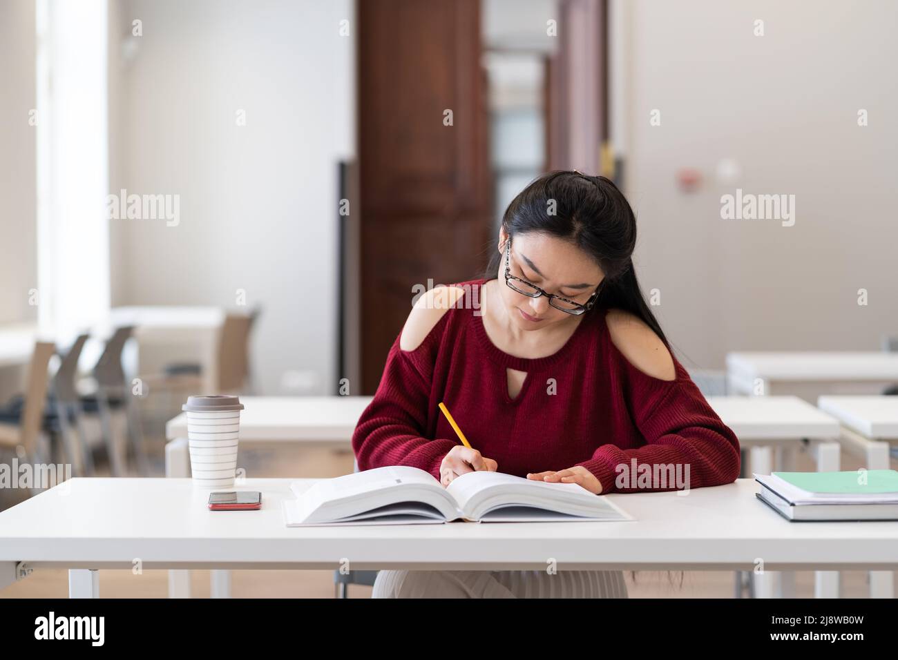 Young girl student study classroom making assessments from book ...