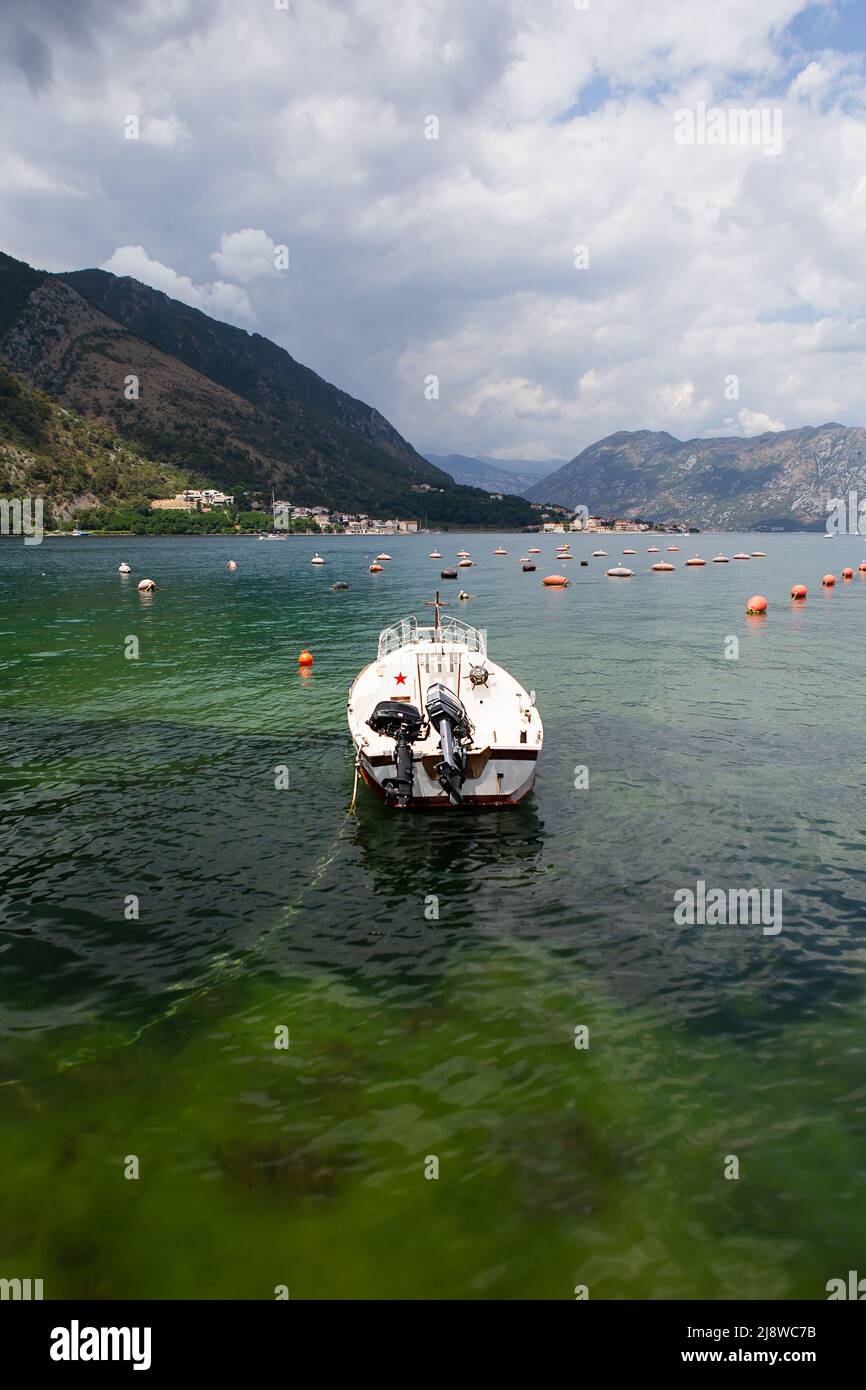 Very beautiful embankment of the Bay of Kotor, a small fishing boat ...