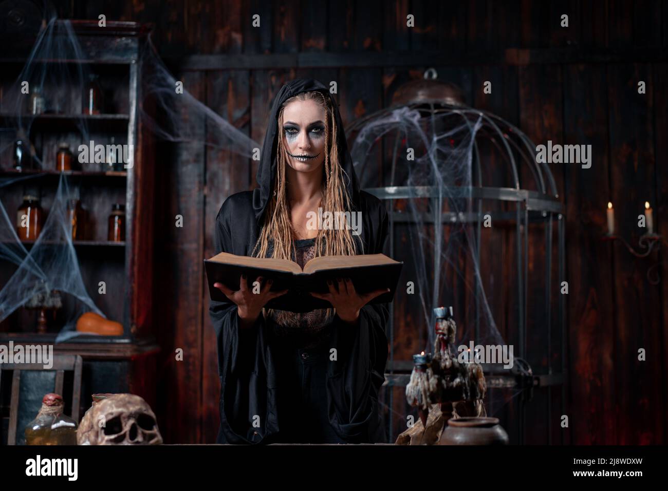 Halloween concept. Witch dressed black hood with dreadlocks standing ...