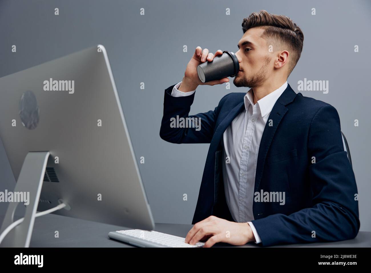 a man in a suit sitting at a desk in front of a computer isolated ...
