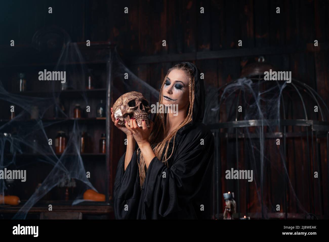 Halloween concept. Witch portrait close up with dreadlocks holding ...