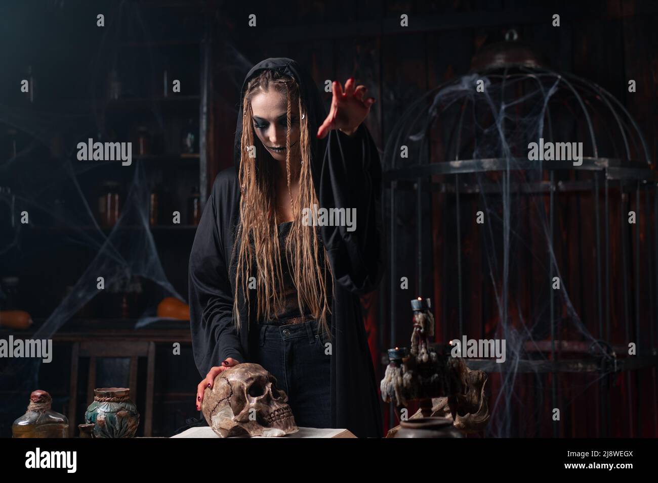 Halloween concept. Witch portrait close up with dreadlocks holding ...