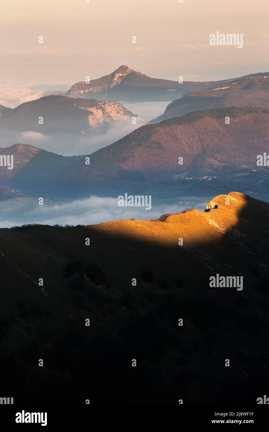 Mist and fog between valley and layers of mountains and hills at sunset ...