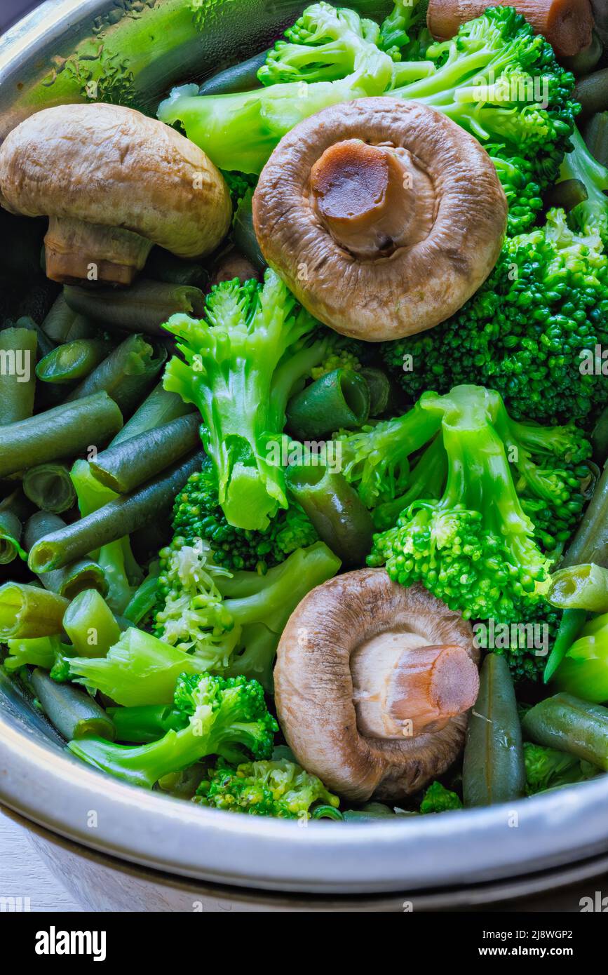 boiled green vegetables in stainless steel colander - full-frame ...