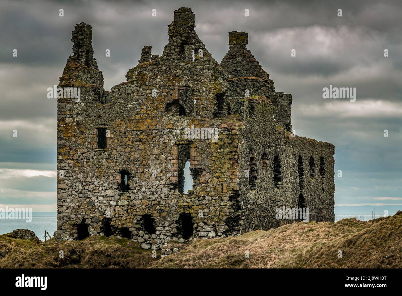Dunskey Castle situated on cliff edge which protrudes into the sea ...
