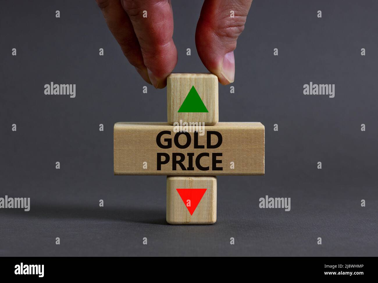 Gold price symbol. Businessman holds a wooden cube with arrow ...