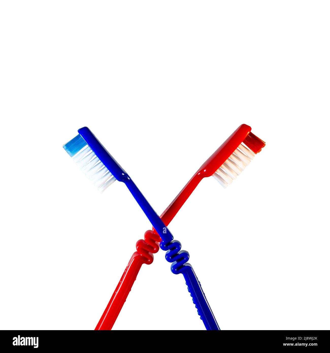 Two toothbrushes crossed on a white background. Blue and red ...