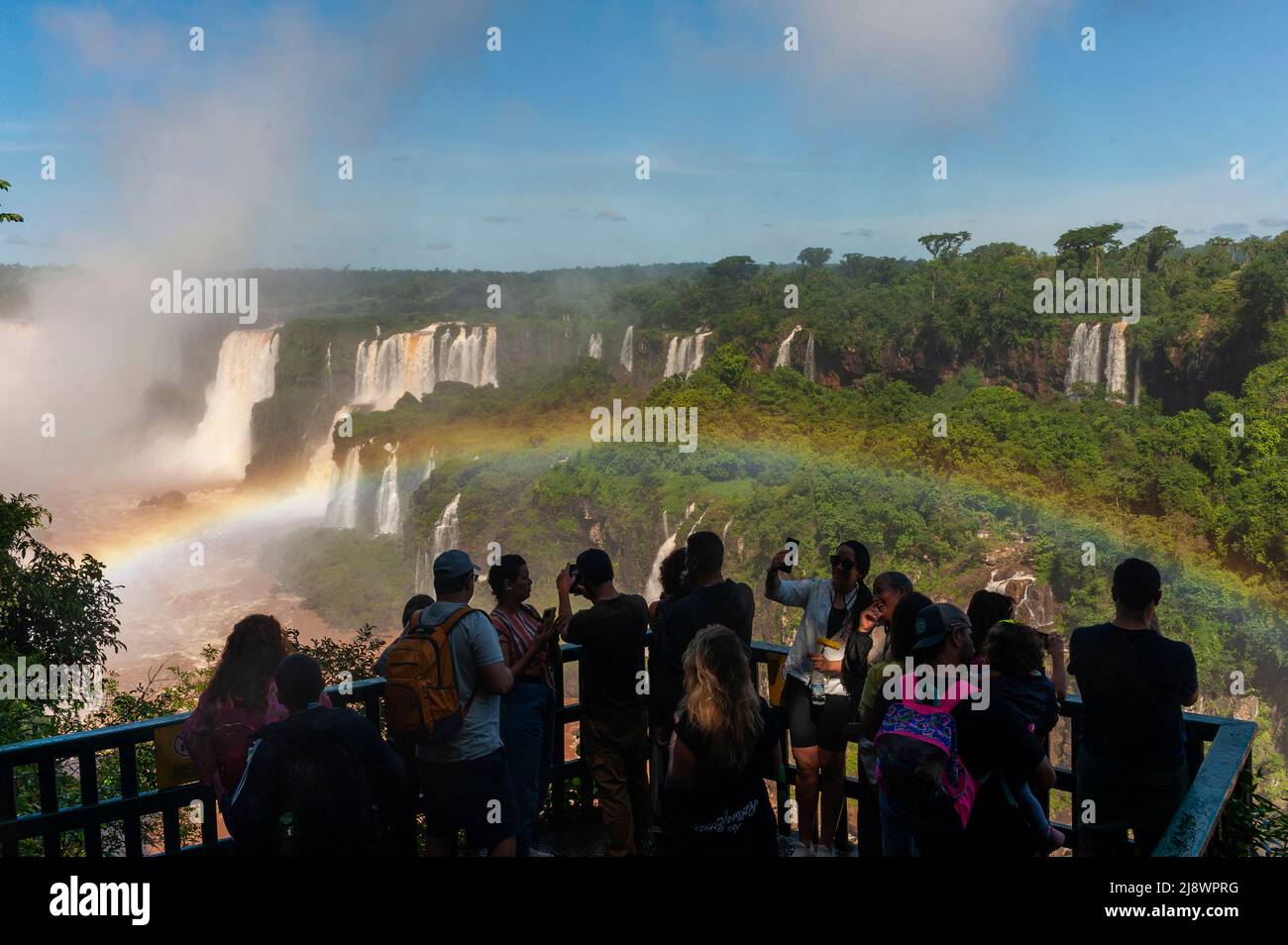 Tourists admiring the Iguazu Falls whilst a rainbow added to the beauty of the scenery, one of ...