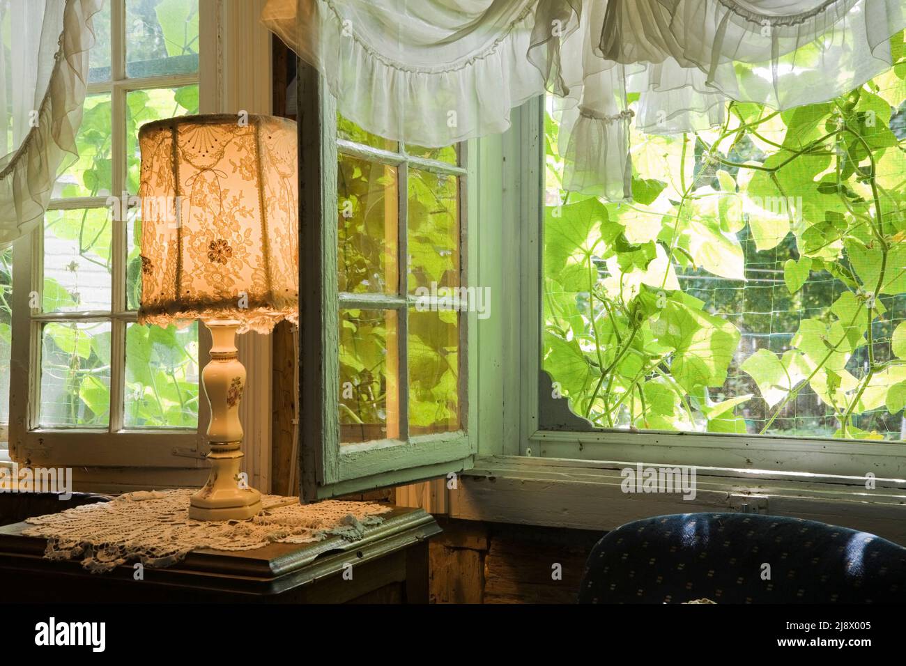 Table lamp and opened glass pane window in living room inside old circa ...