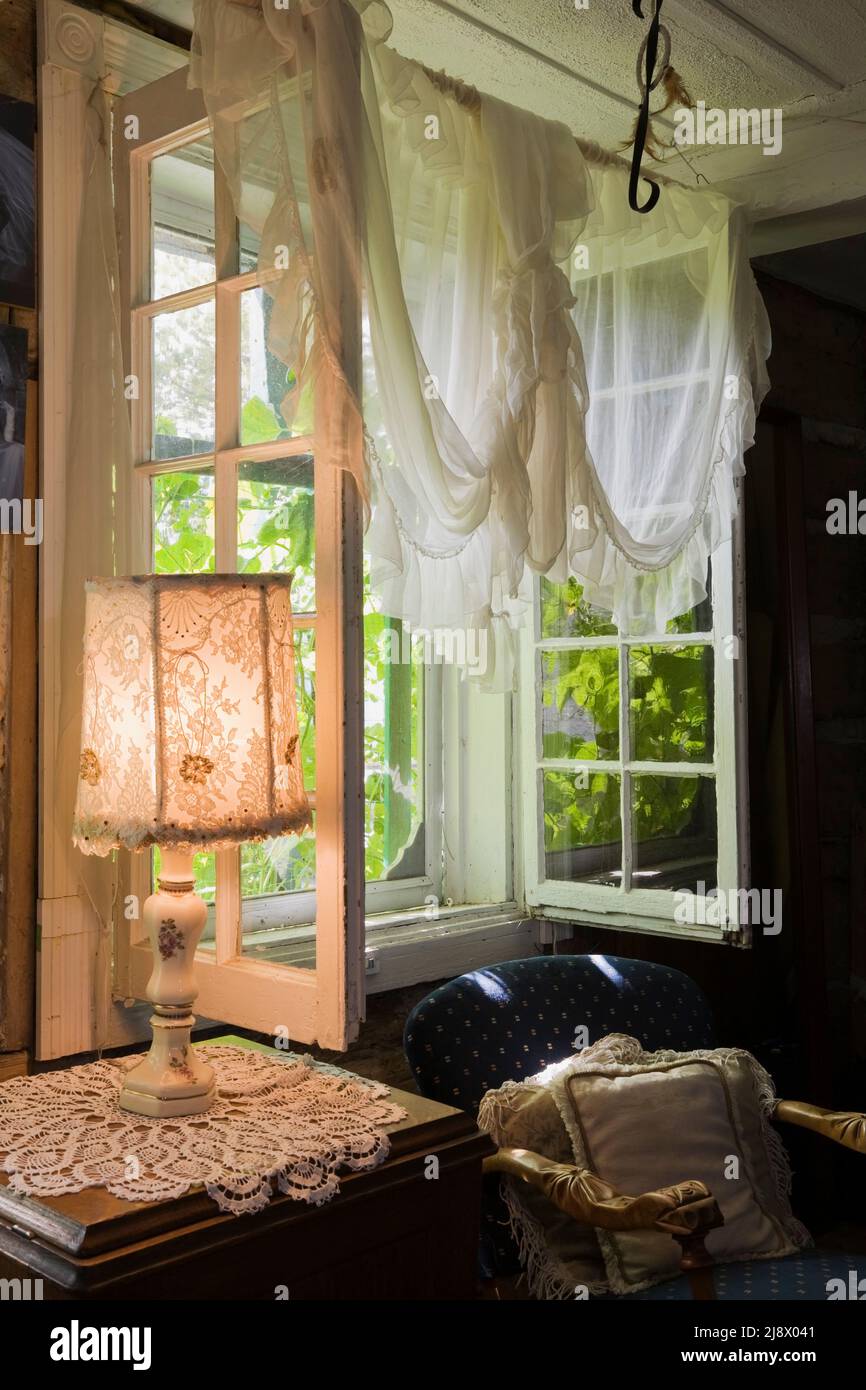 Table lamp and opened glass pane window in living room inside old circa ...