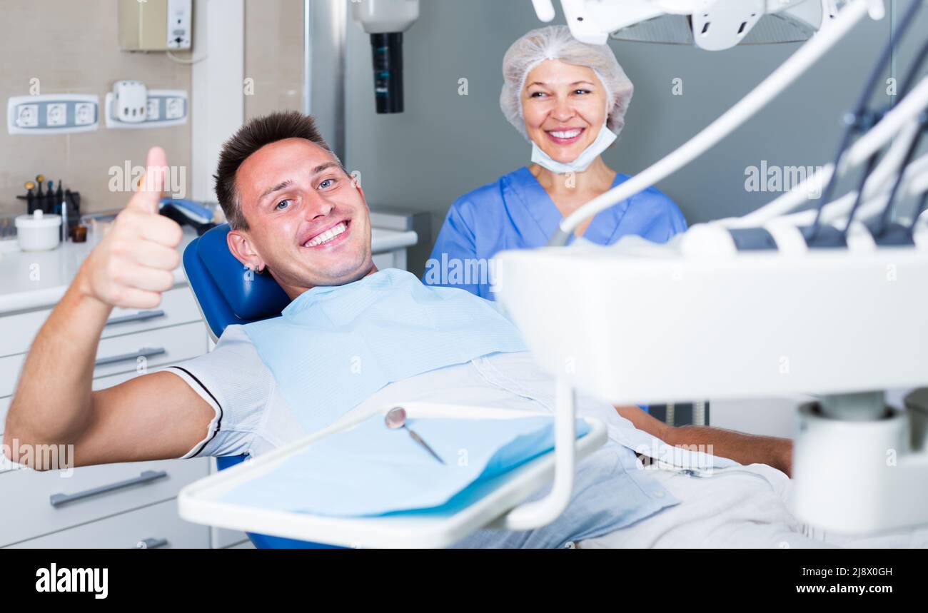 Portrait of smiling man visiting dentist giving thumbs up Stock Photo ...