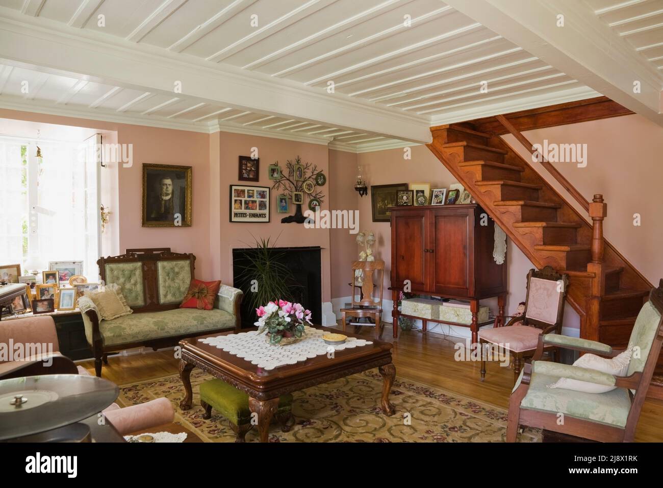 Antique furniture and furnishings in pink painted living room inside ...