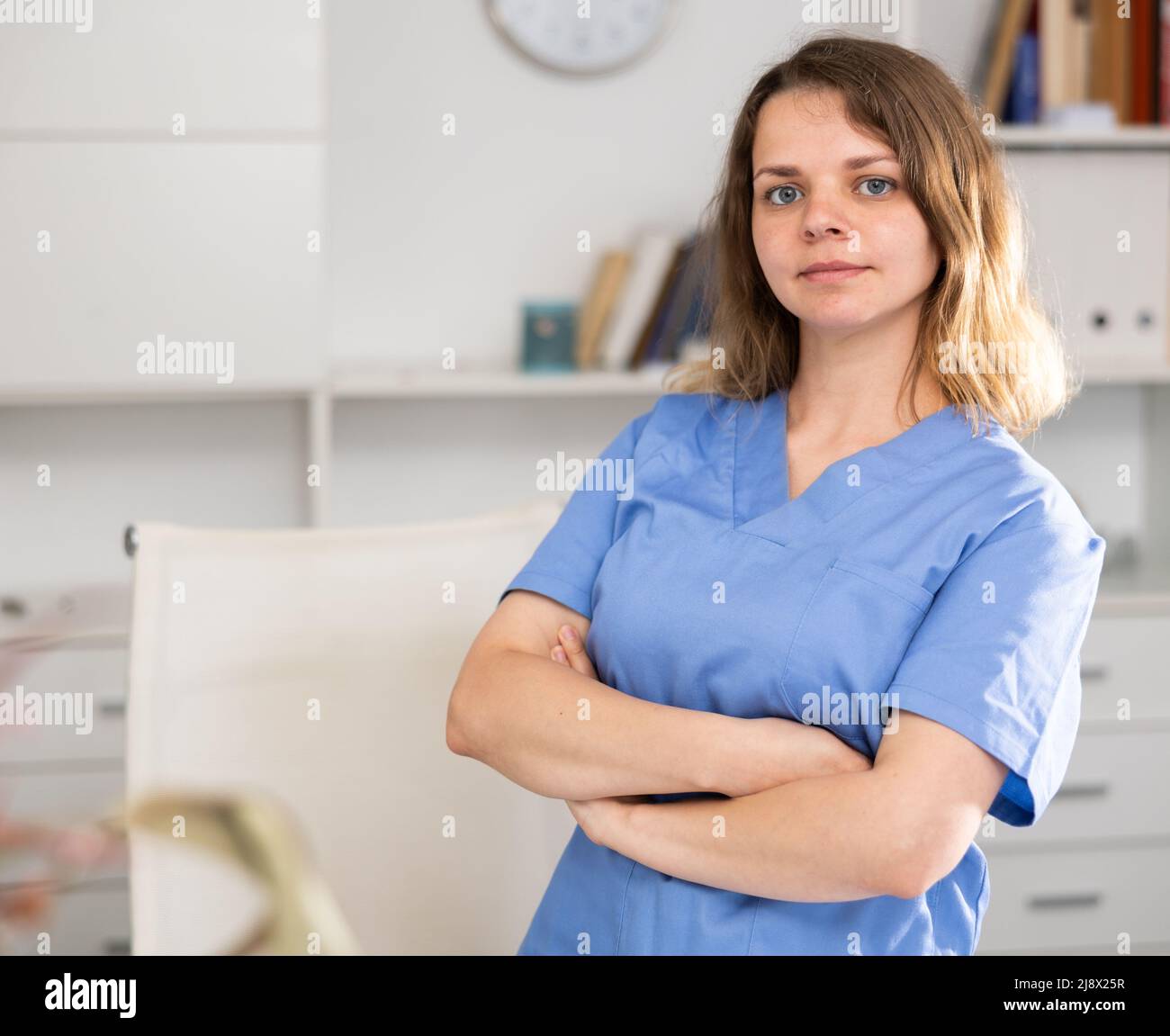 Portrait of female doctor who is working and posing on her workplace in ...