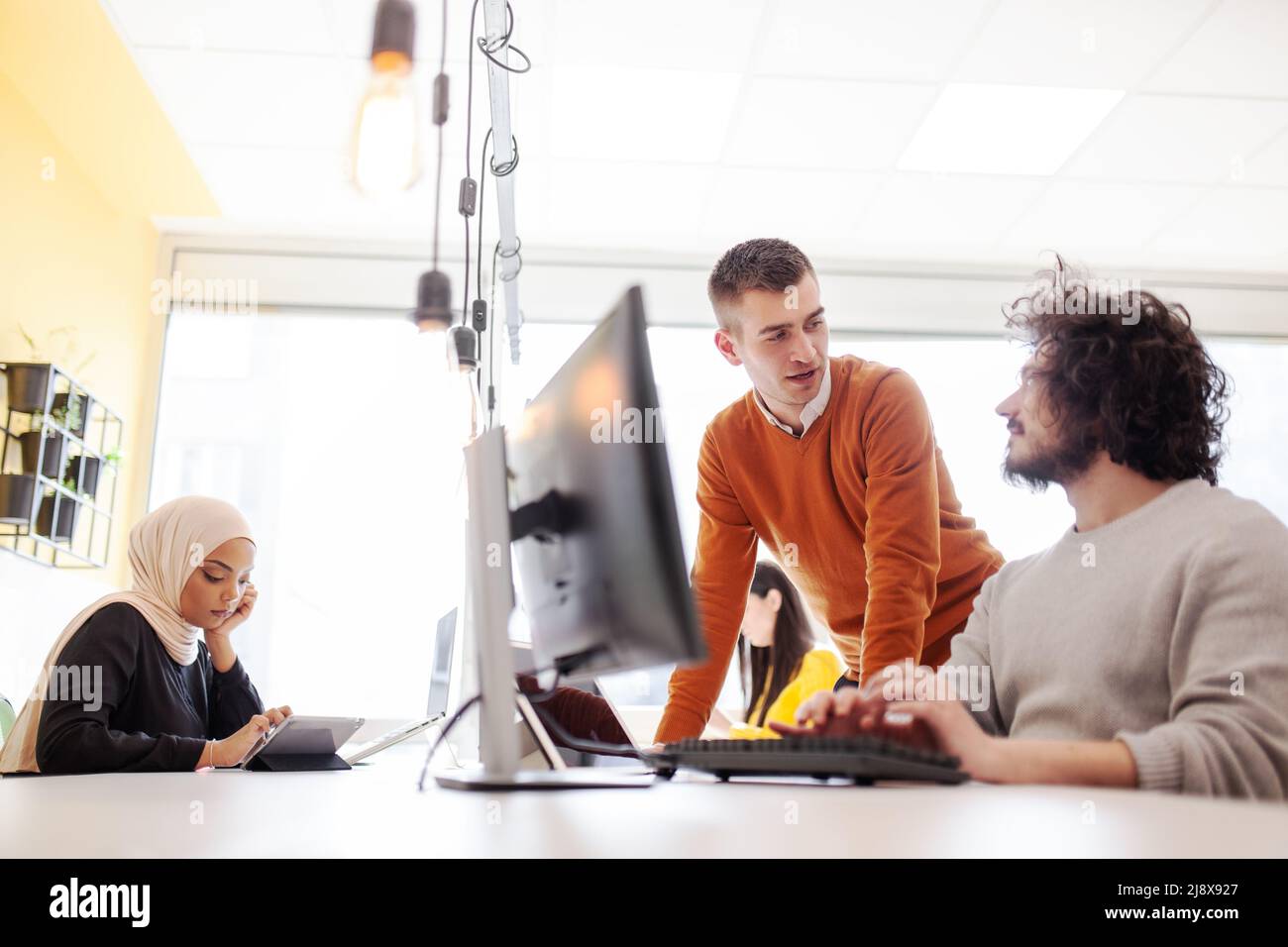 Business people having conversation in front of a computer. Modern ...