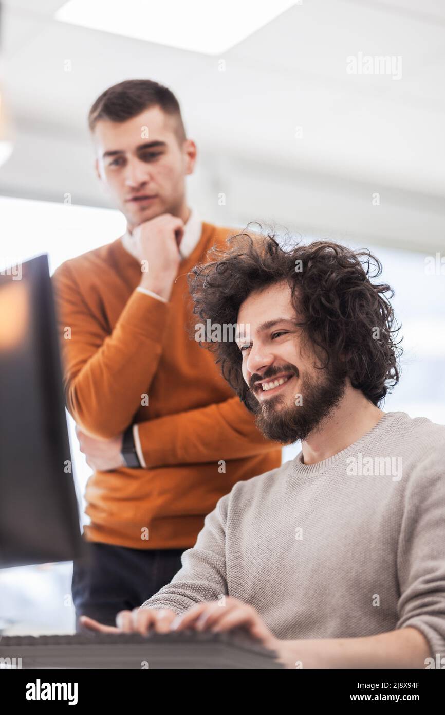 Business people having conversation in front of a computer in modern ...