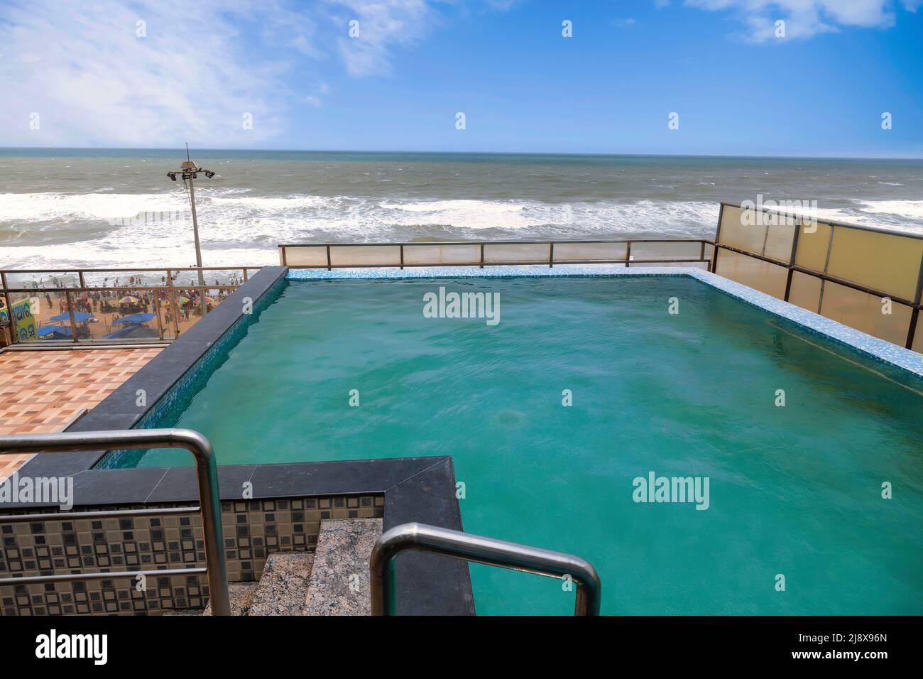 Hotel rooftop swimming pool overlooking the sea shore at Puri Odisha ...