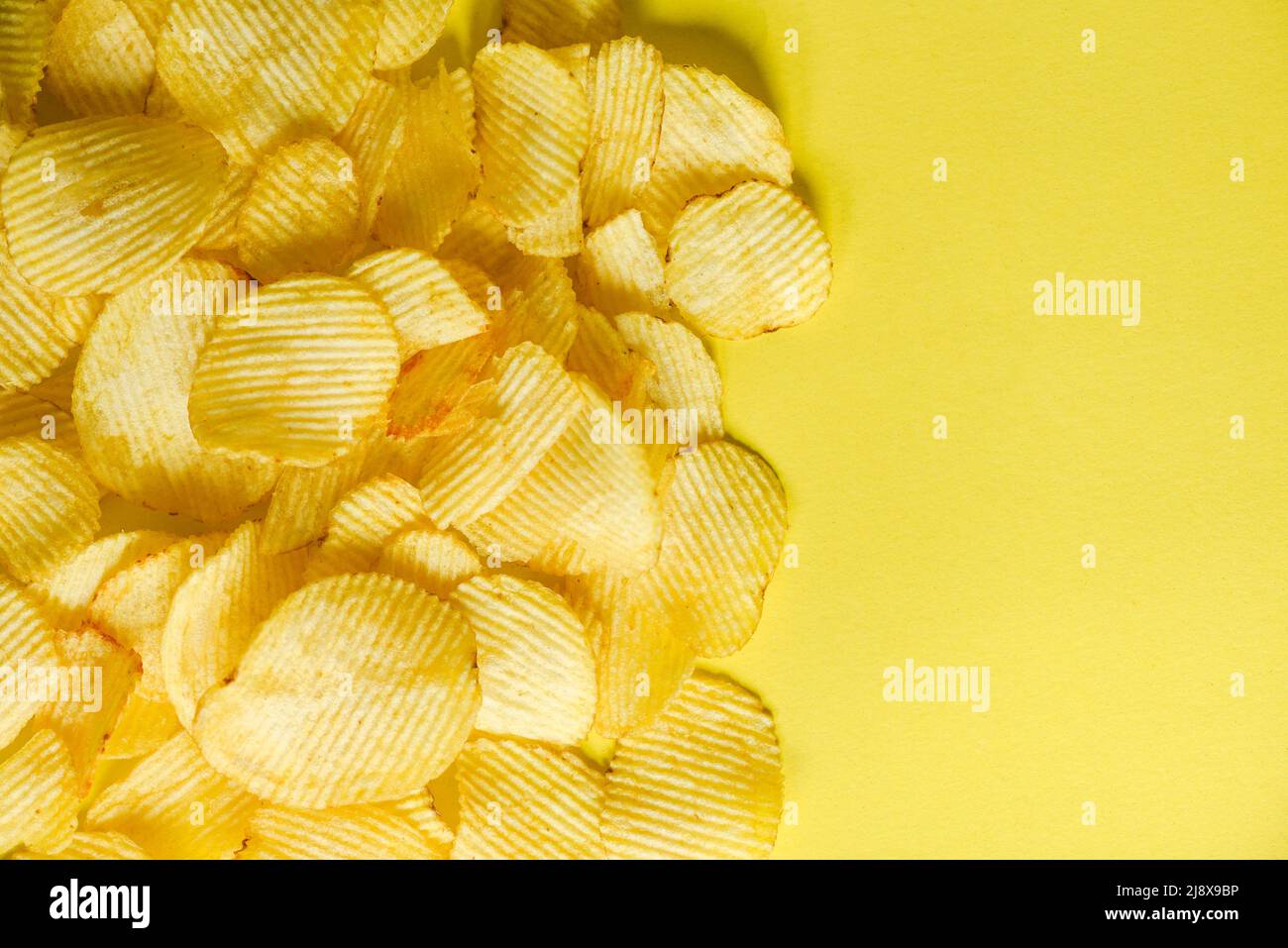 Crispy potato top view, Potato chips snack on yellow background Stock ...