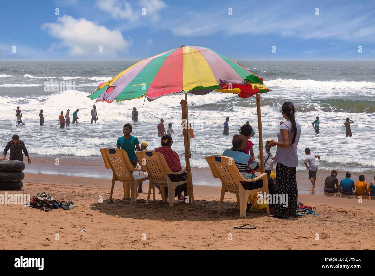 Tourist relax after a bath under an umbrella at Puri sea beach at ...