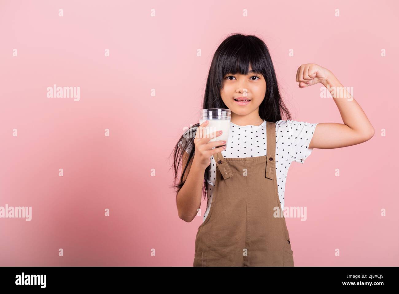 Asian little kid 10 years old smile holding milk glass and show power ...