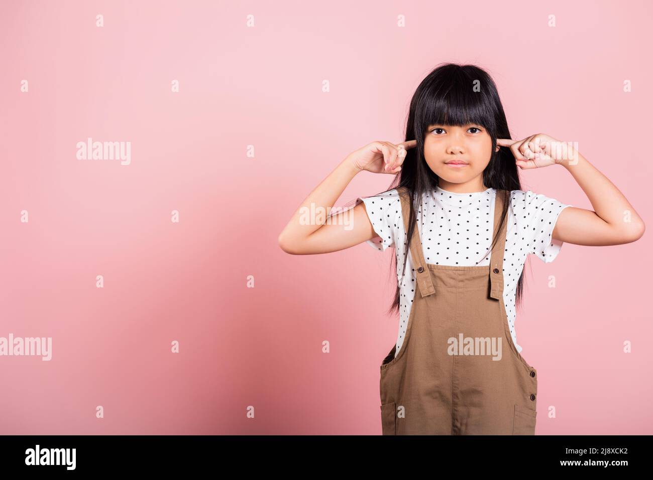 Asian little kid 10 years old Close her ears with fingers and eyes at ...