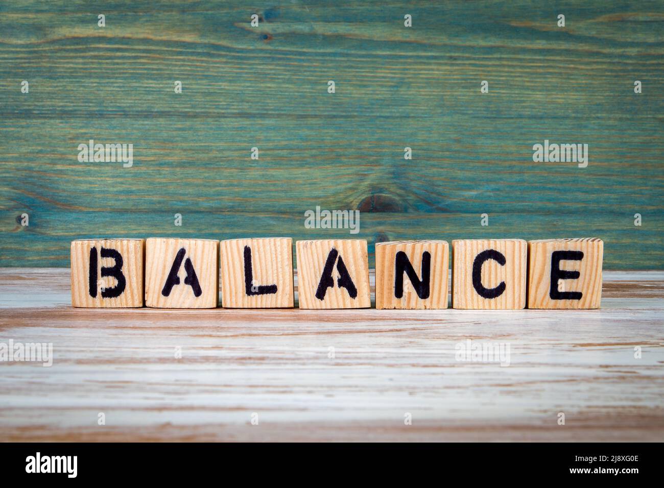 BALANCE. Word from wooden alphabet blocks on a green and white ...