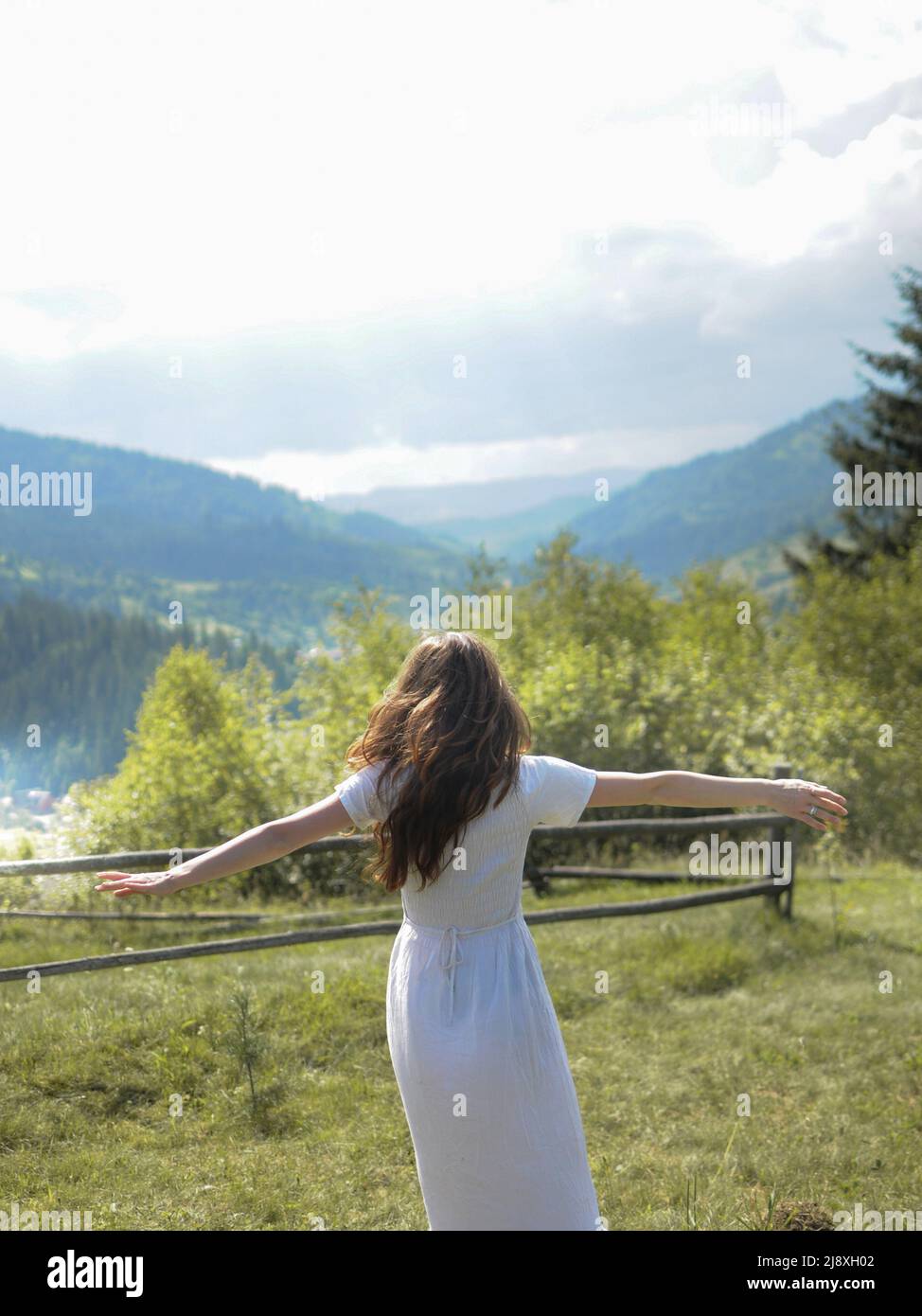 Happy young woman is turning round in the field. Freedom feeling in the ...