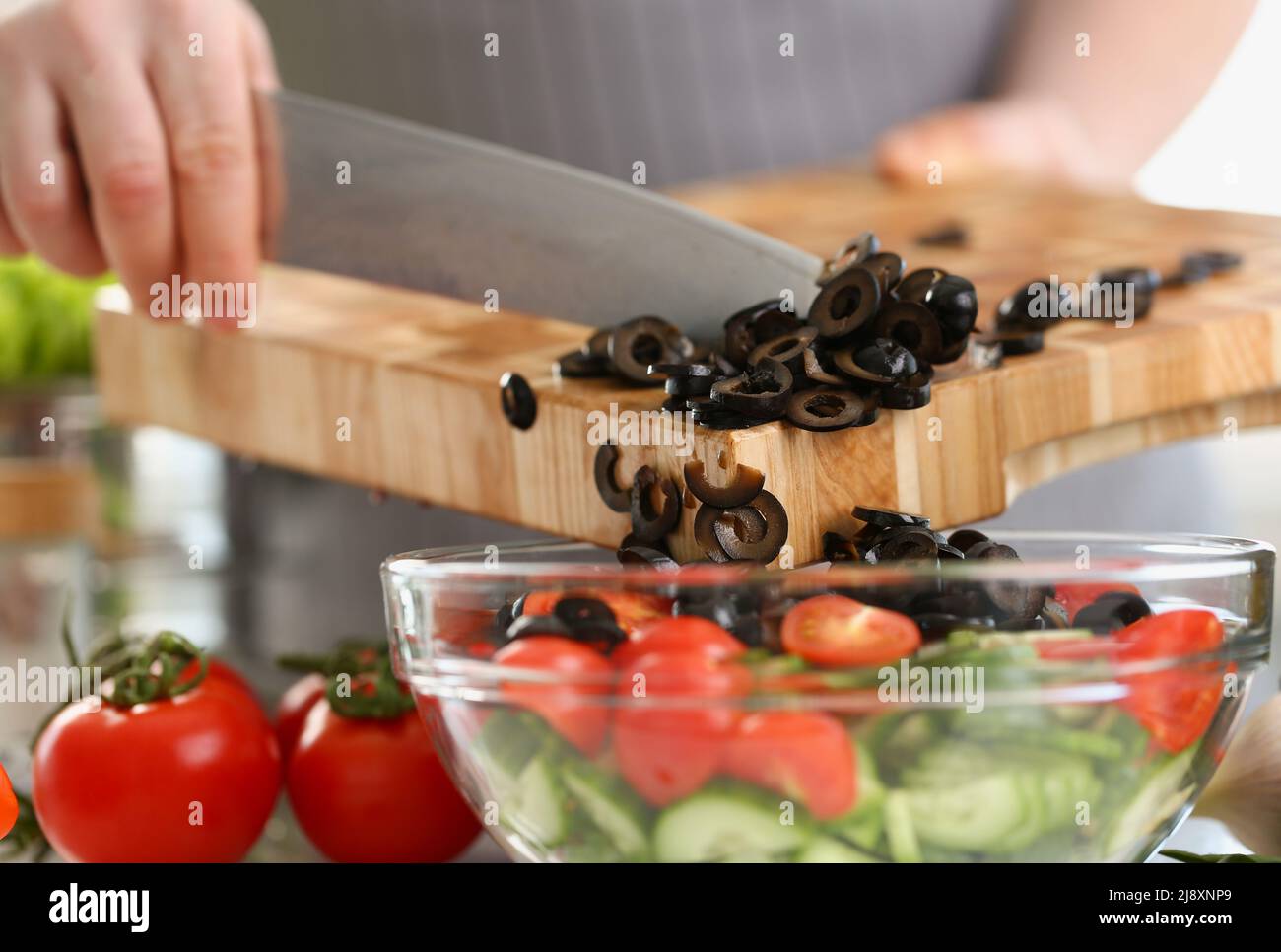 Man chef cutting olives, ripe vegetable ingredient for fresh spring ...